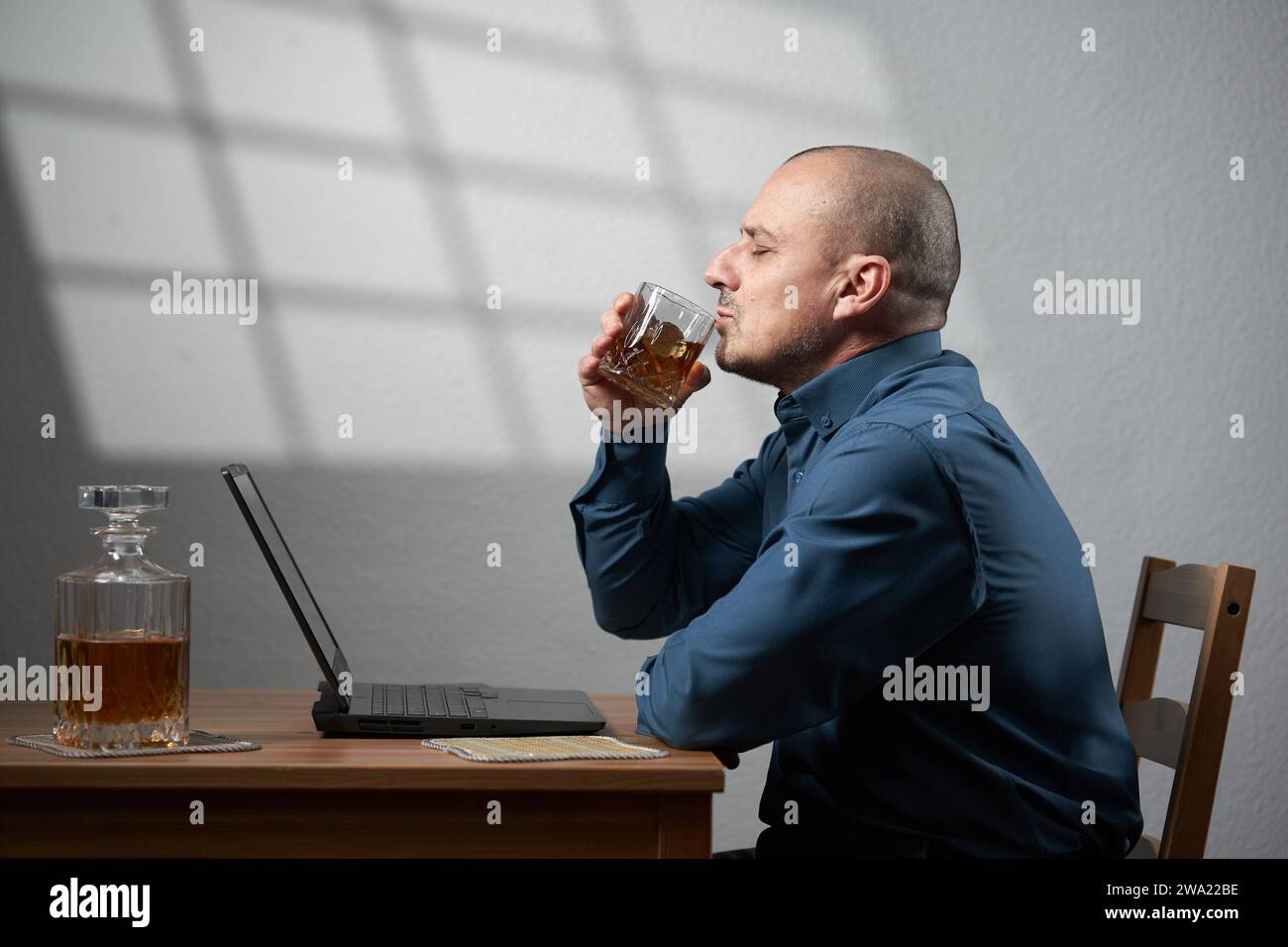 Drinking at work - business man with a glass of whisky in front of his ...