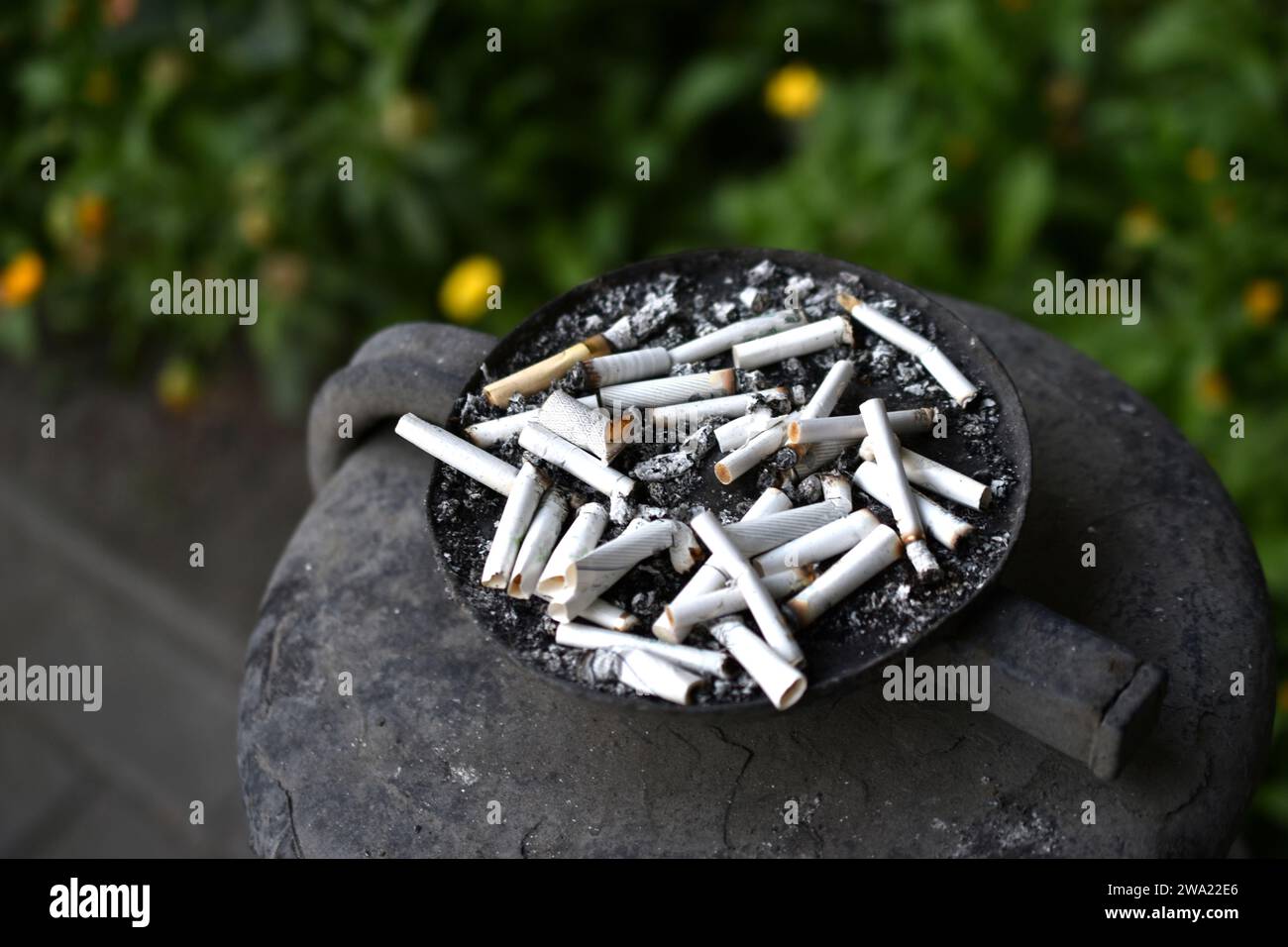 An ashtray for cigarette butts on the street. Smoked cigarettes in the ...