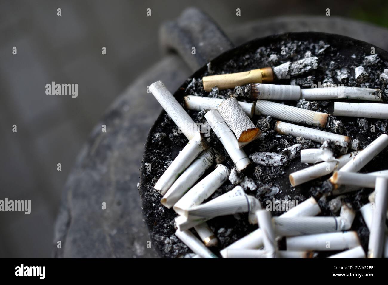 An ashtray for cigarette butts on the street. Smoked cigarettes in the ...
