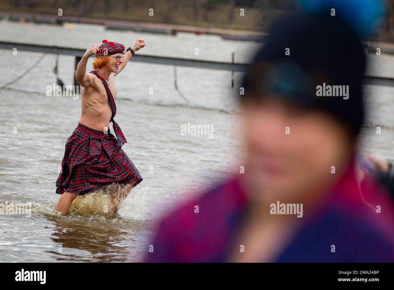 Haltern Am See, Germany. 01st Jan, 2024. A swimmer in a kilt flexes his ...