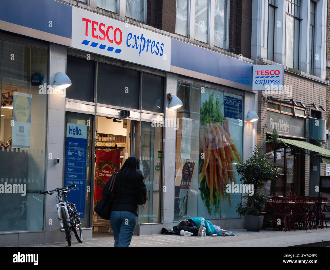 London, UK. Tesco express shop in Central London, with homeless man ...