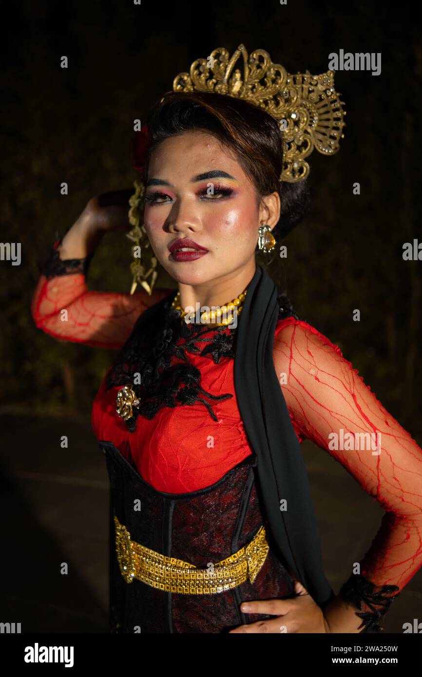 an Asian woman with makeup on her face and wearing a black shawl while ...