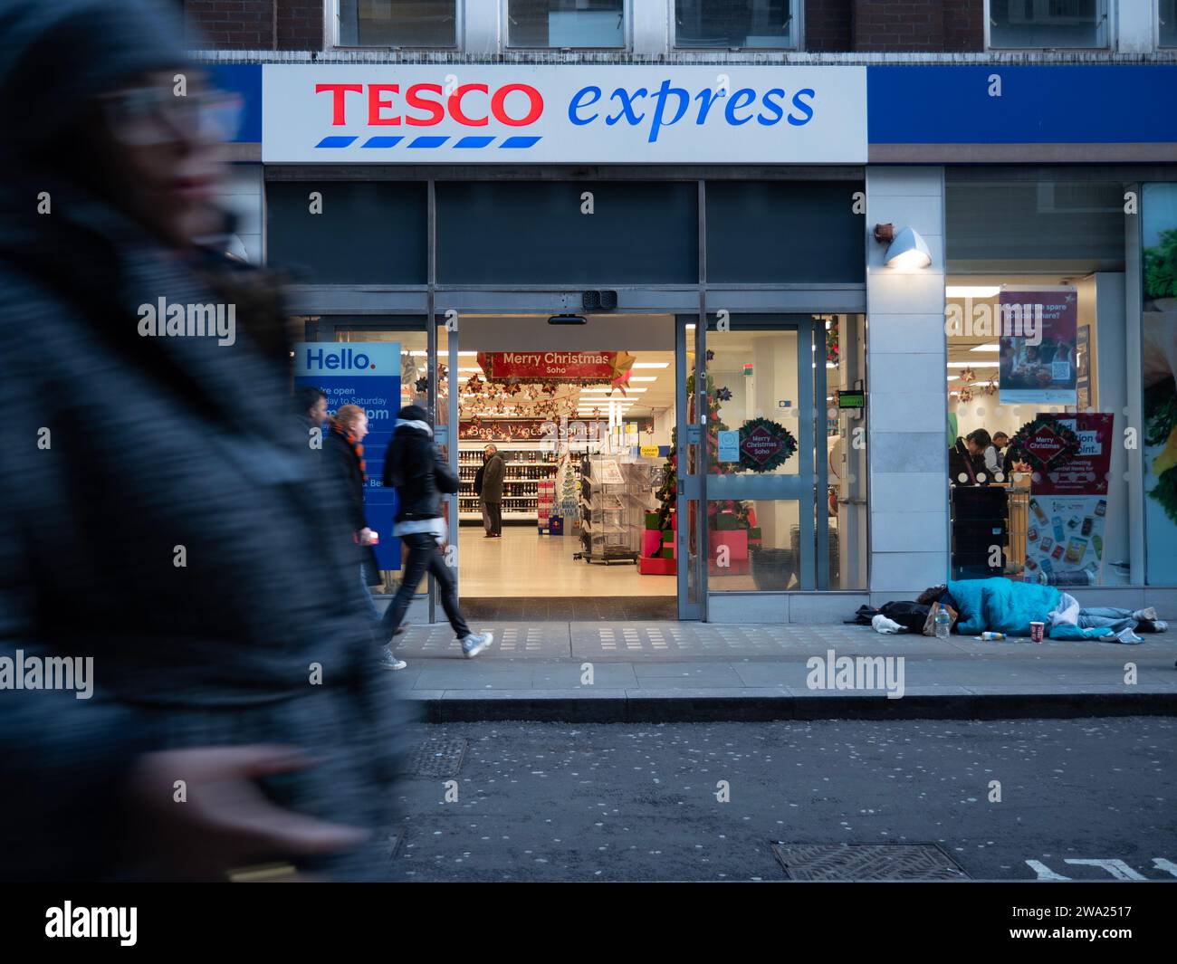 London, UK. Tesco express shop in Central London, with homeless man ...