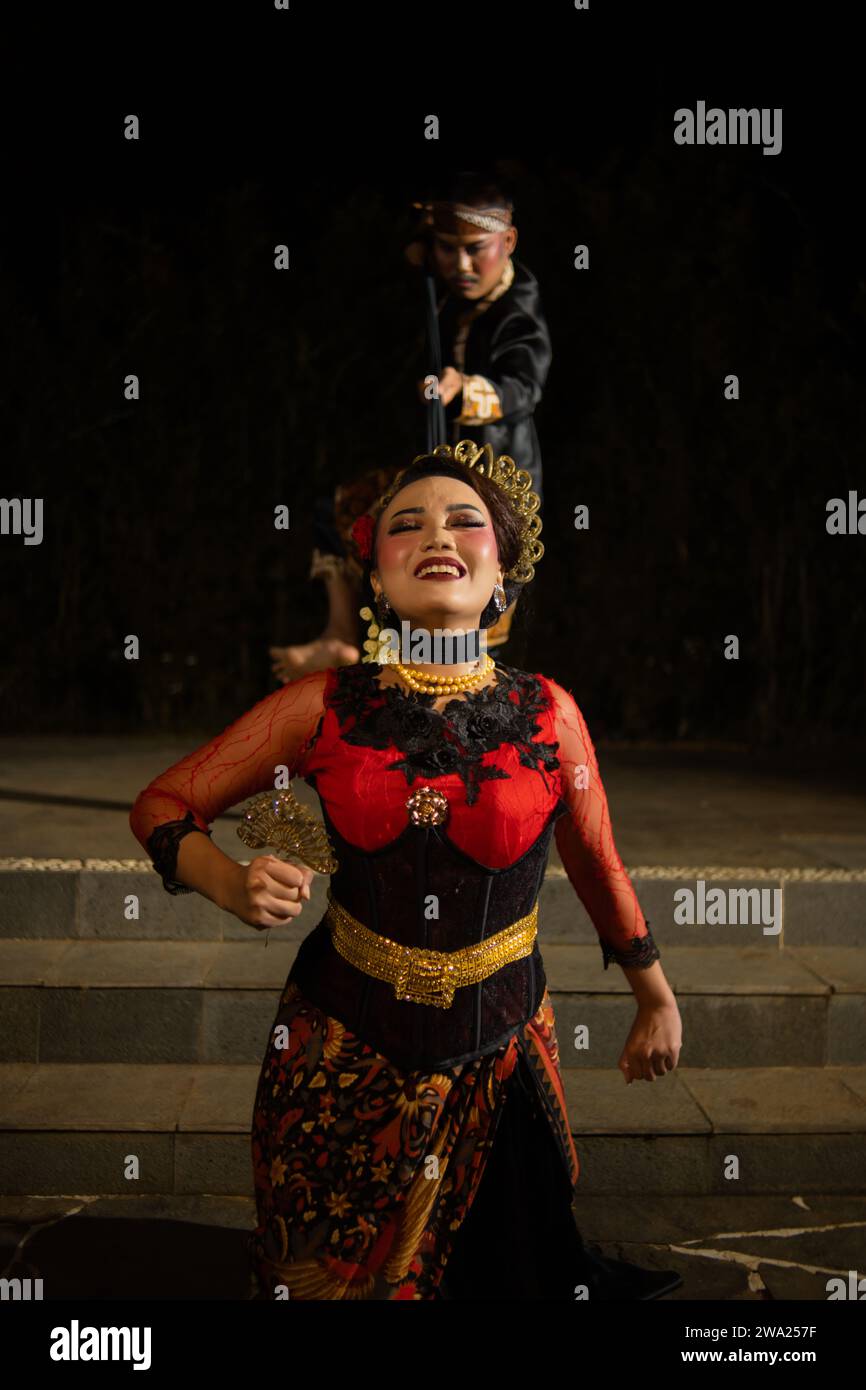 female dancers tied by black scarves while being held by men with sad ...