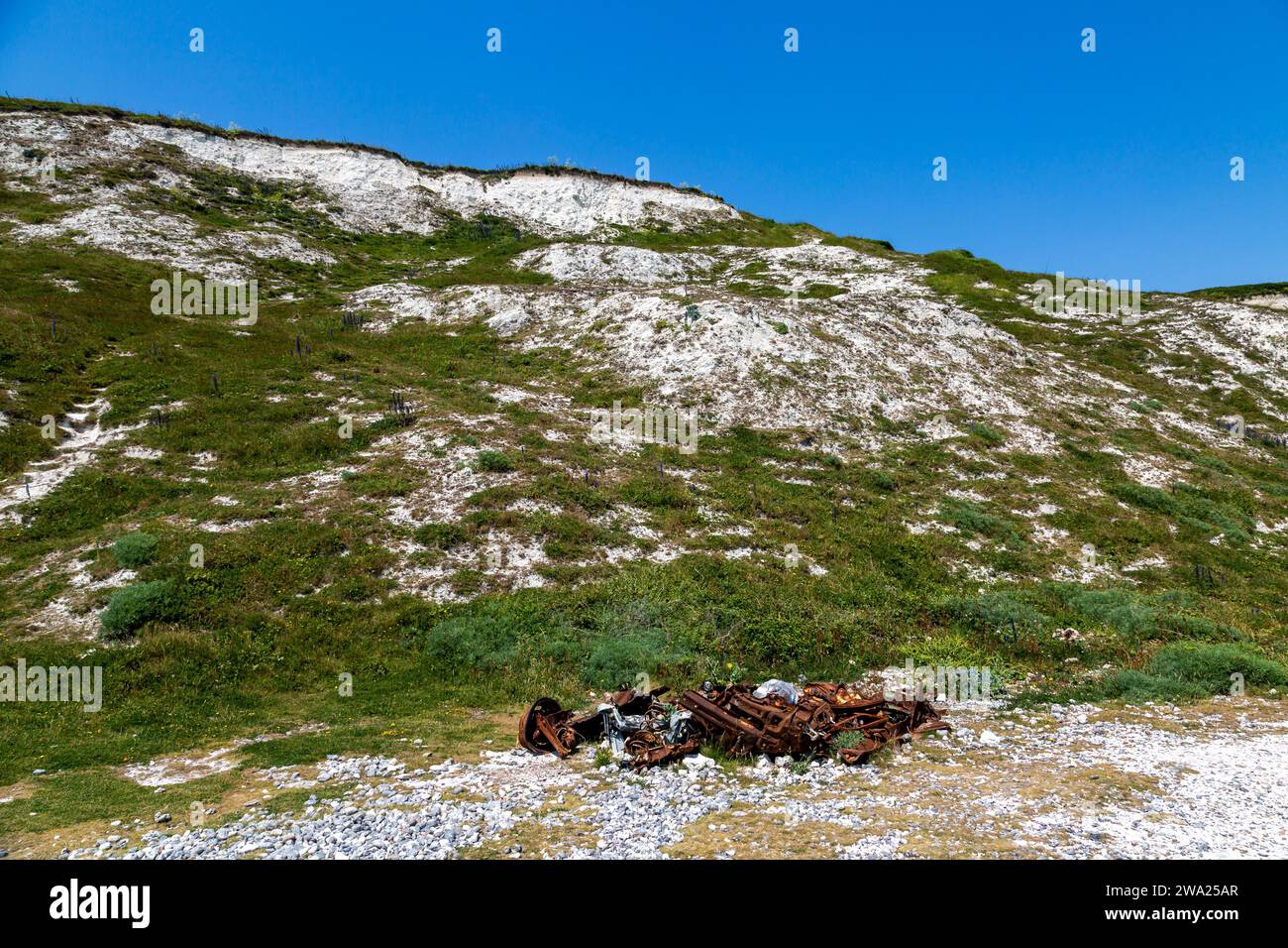 An old rusty car on the beach below cliffs near Beachy Head in Sussex ...