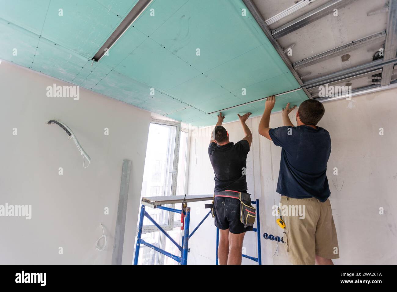 Construction worker ceiling work installation Stock Photo - Alamy