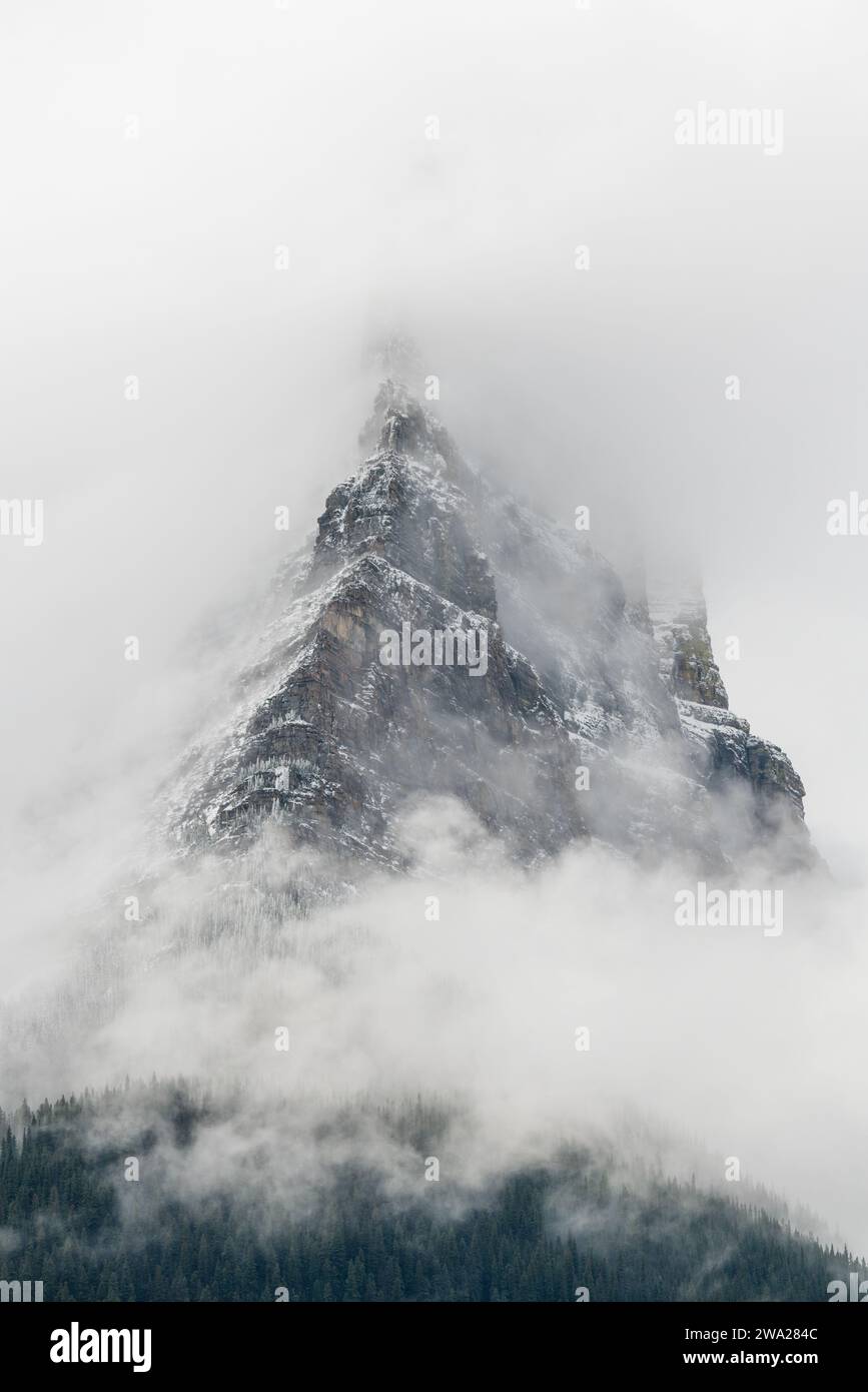 A mountain peak shrouded in cloud in Glacier National Park, Montana ...
