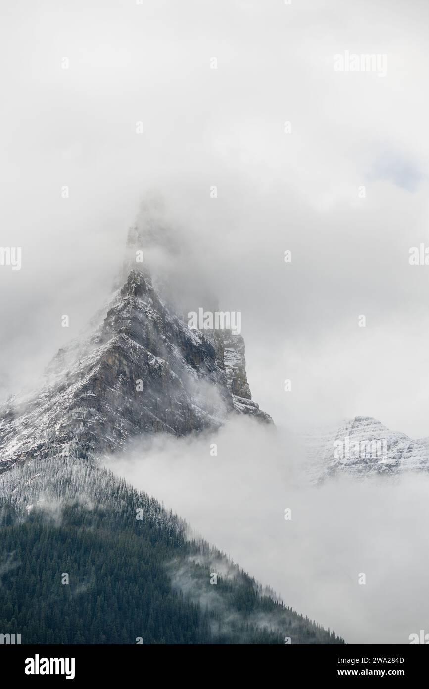 A mountain peak shrouded in cloud in Glacier National Park, Montana ...
