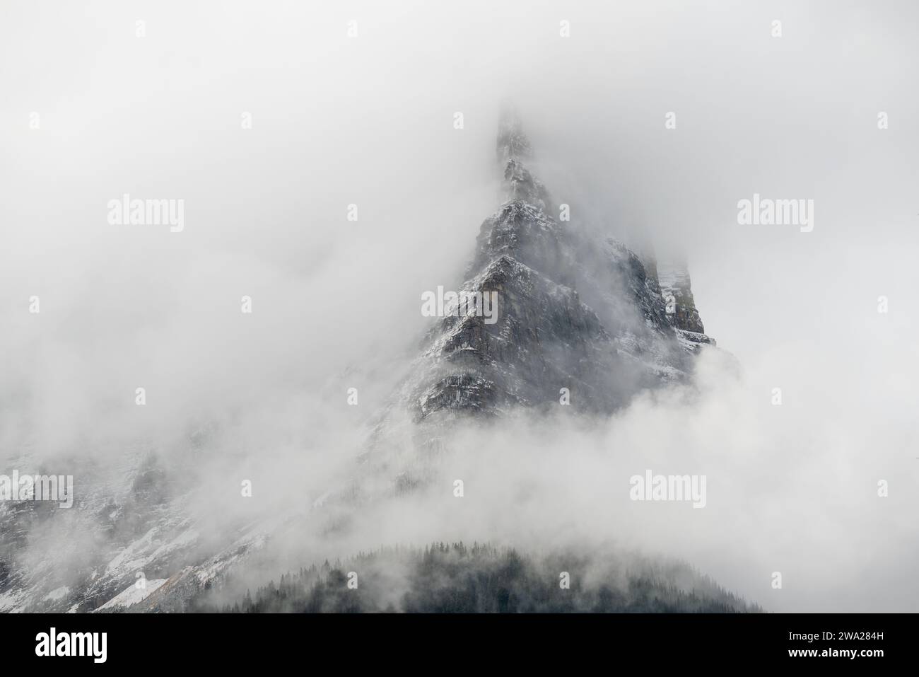 A mountain peak shrouded in cloud in Glacier National Park, Montana ...