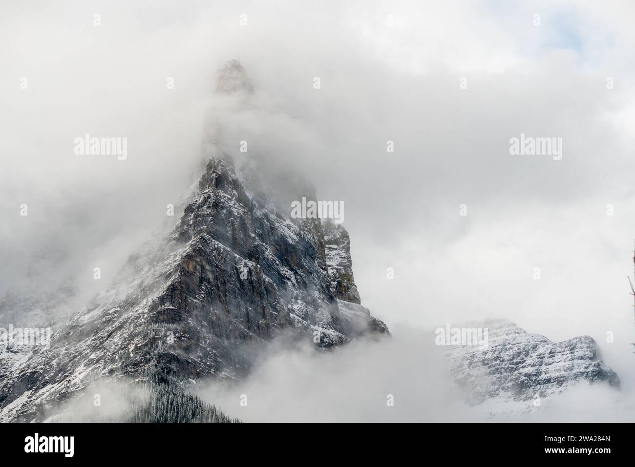 A mountain peak shrouded in cloud in Glacier National Park, Montana ...