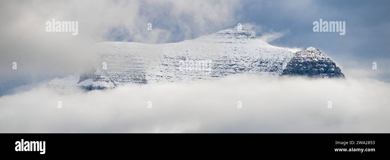 A mountain peak shrouded in cloud in Glacier National Park, Montana ...