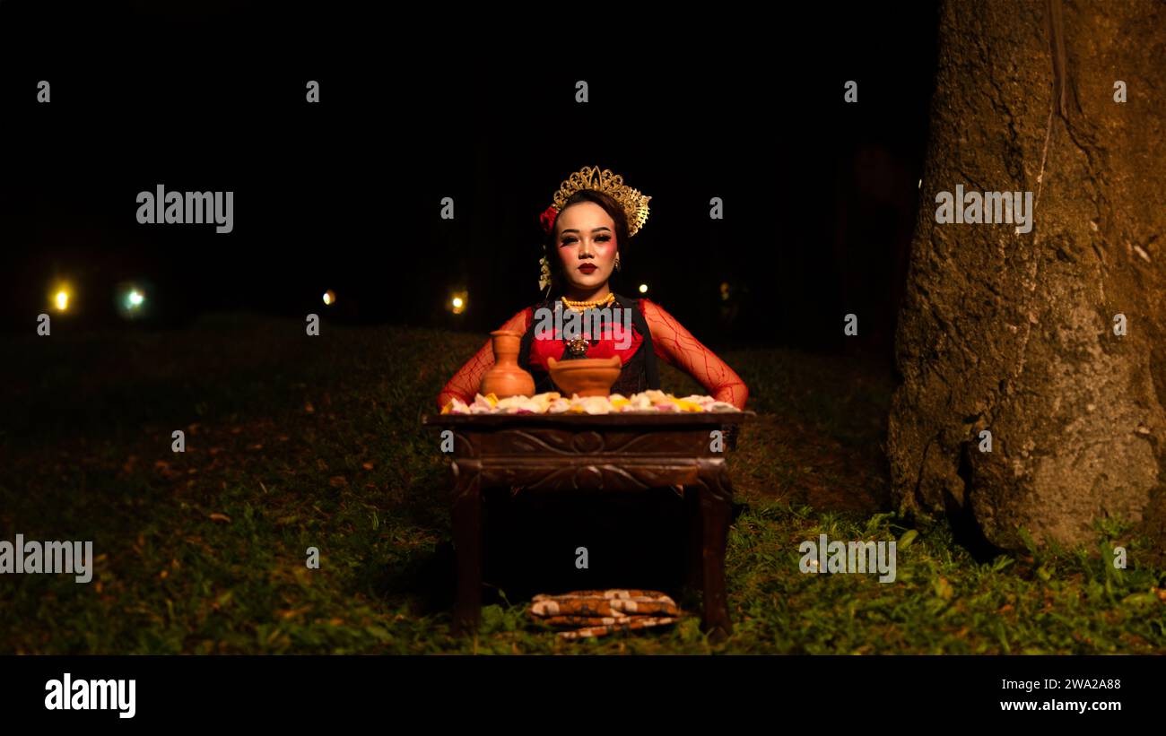 a female dancer looks focused on her ritual with a peaceful facial ...