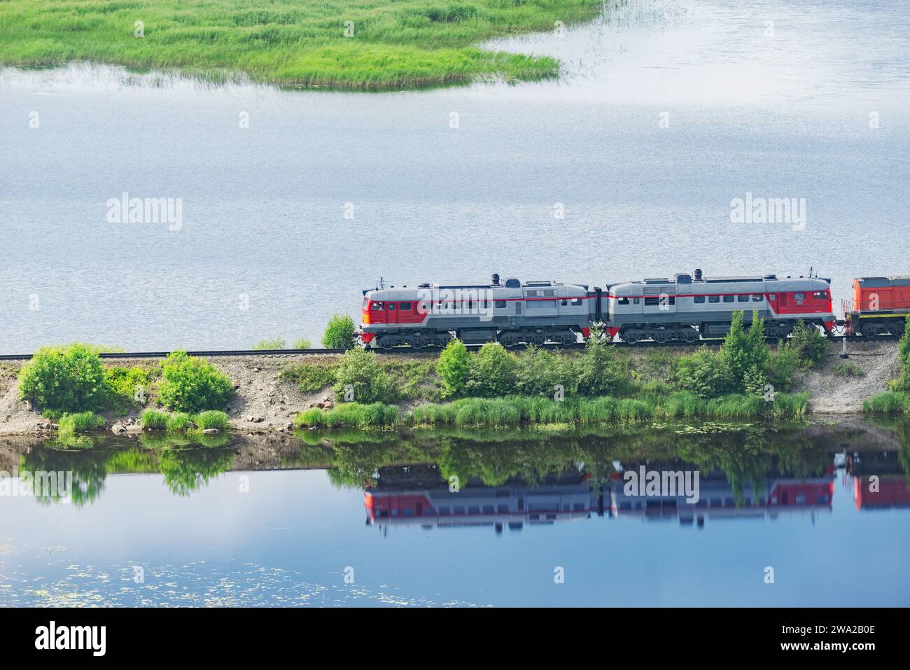Freight train moves along the lake Stock Photo - Alamy