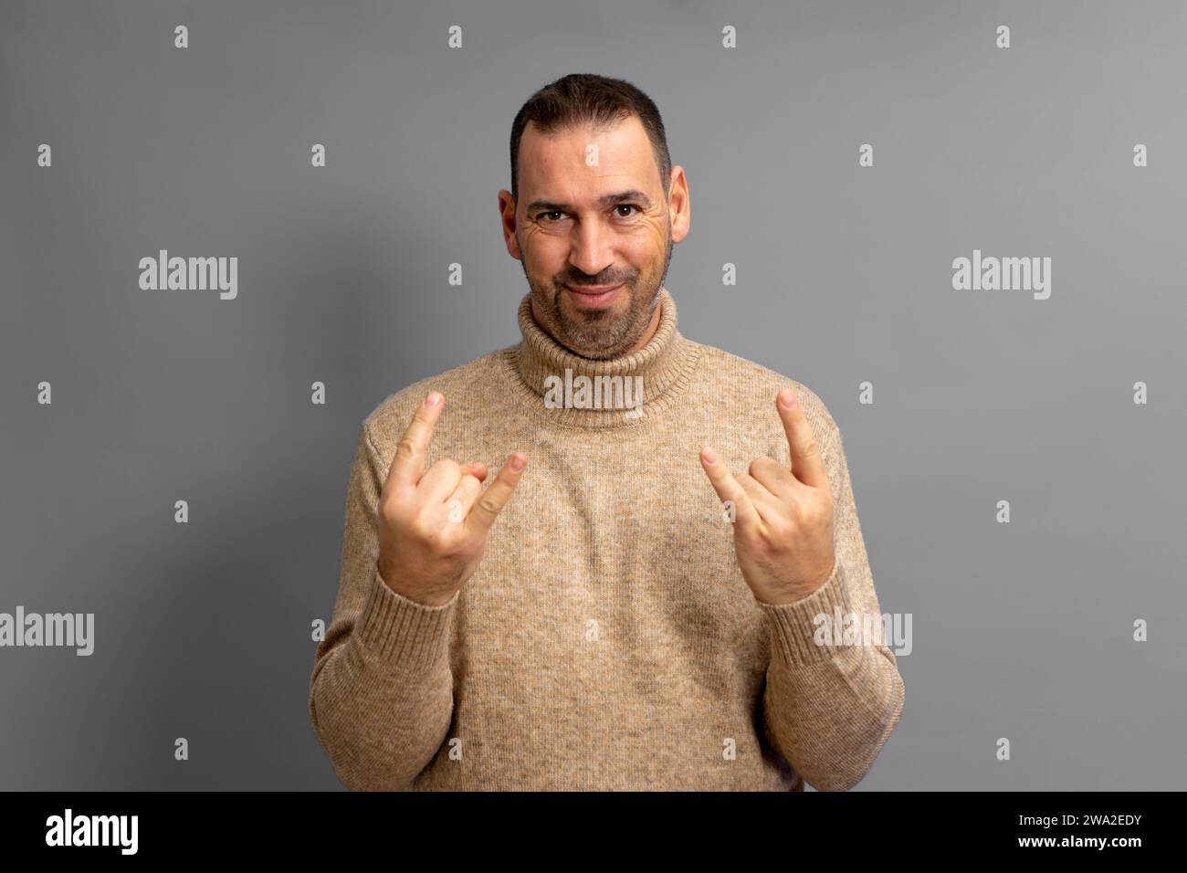 Handsome man with beard in his 40s standing over gray background with ...