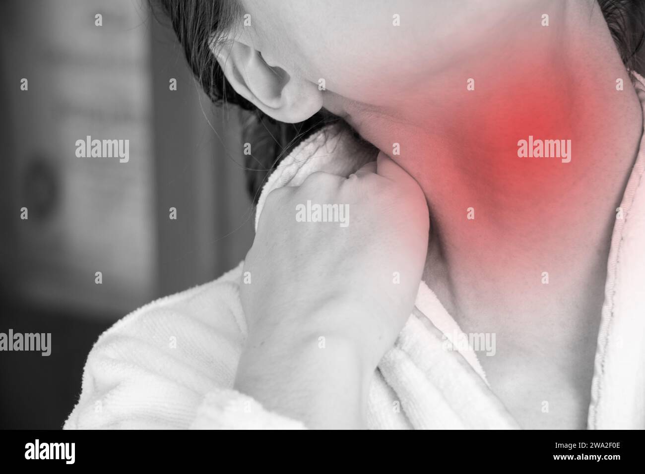 A girl holds her hands behind her neck at home in a dressing gown, her ...