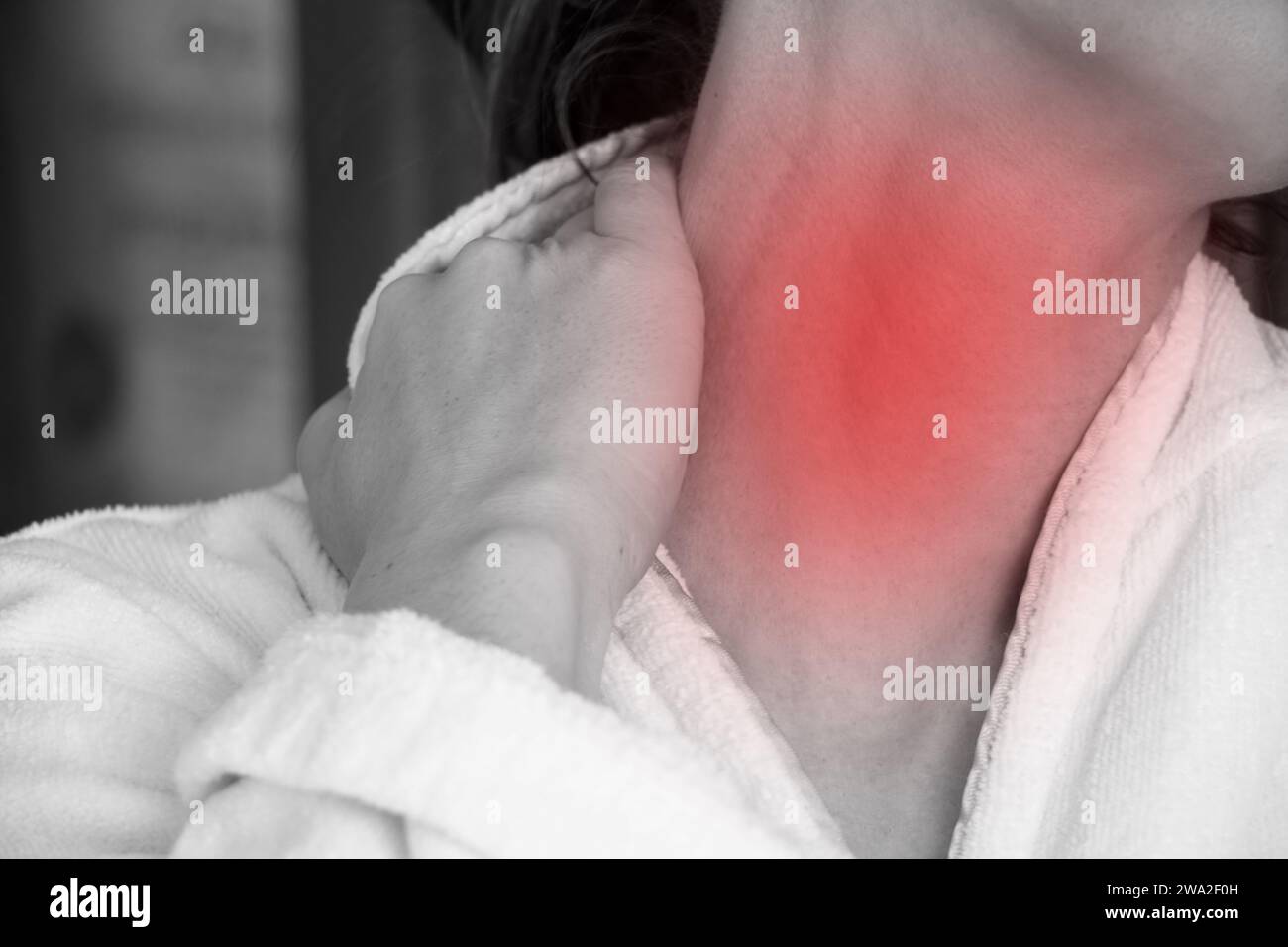 A girl holds her hands behind her neck at home in a dressing gown, her ...