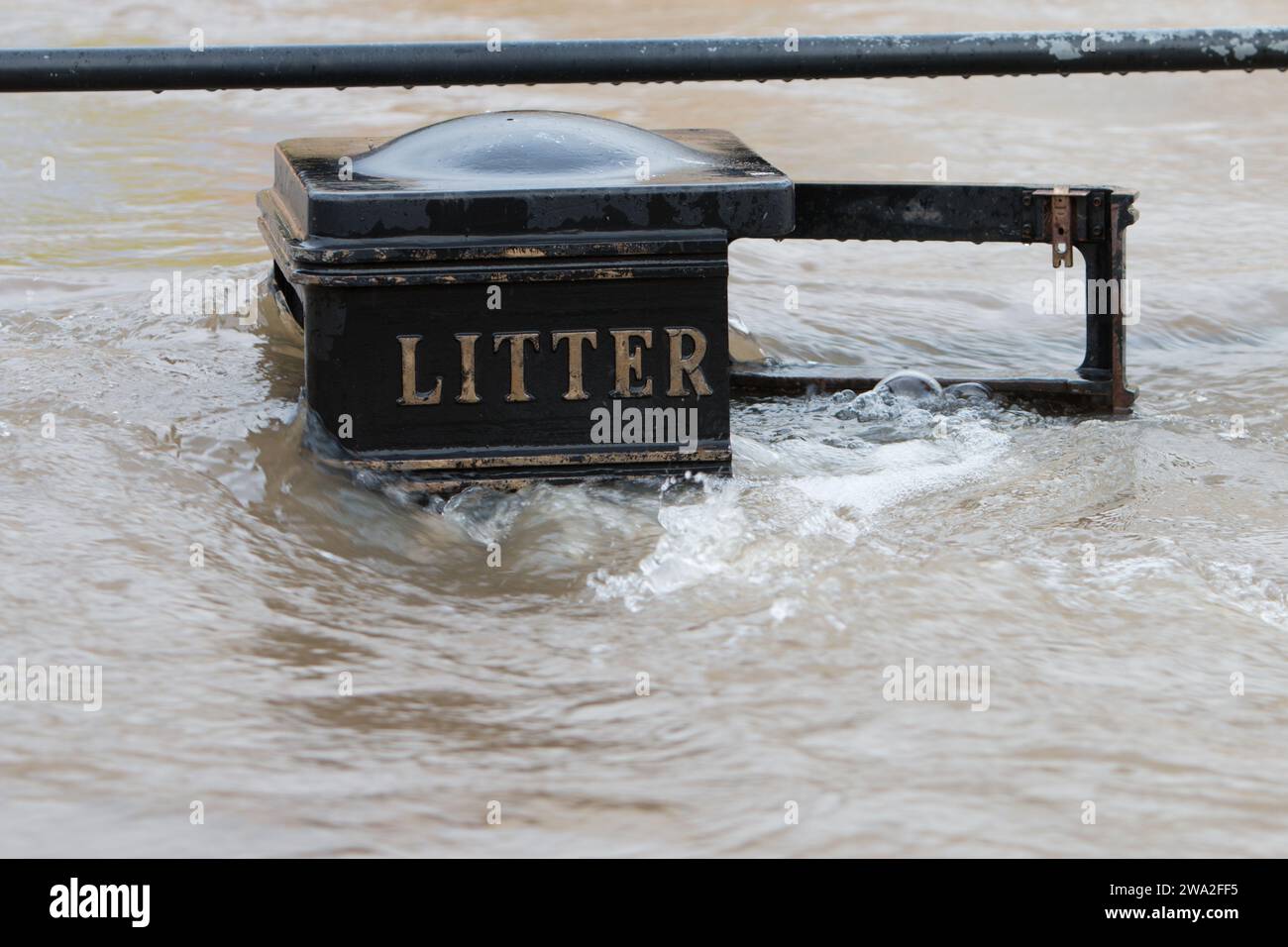 The River Severn in flood covering railings and a litter bin on its ...