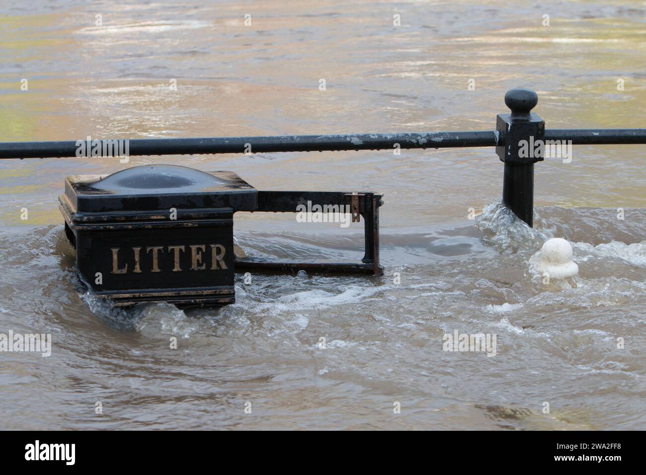 The River Severn in flood covering railings and a litter bin on its ...