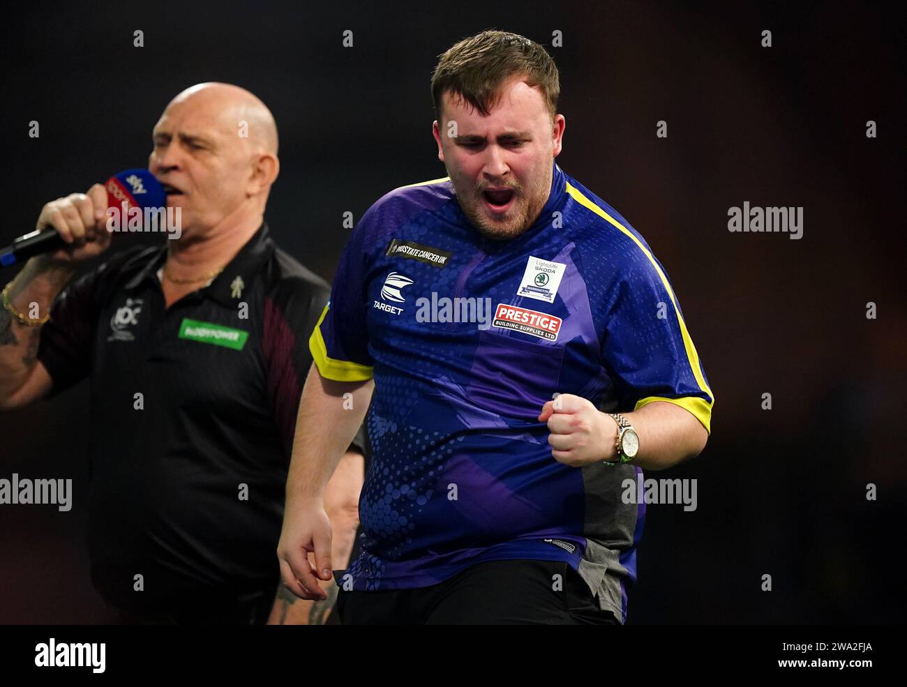 Luke Littler reacts during his match against Brendan Dolan (right) on ...