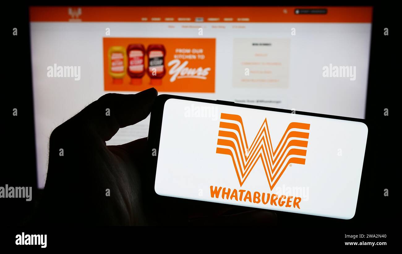 Person holding mobile phone with logo of American fast food company ...