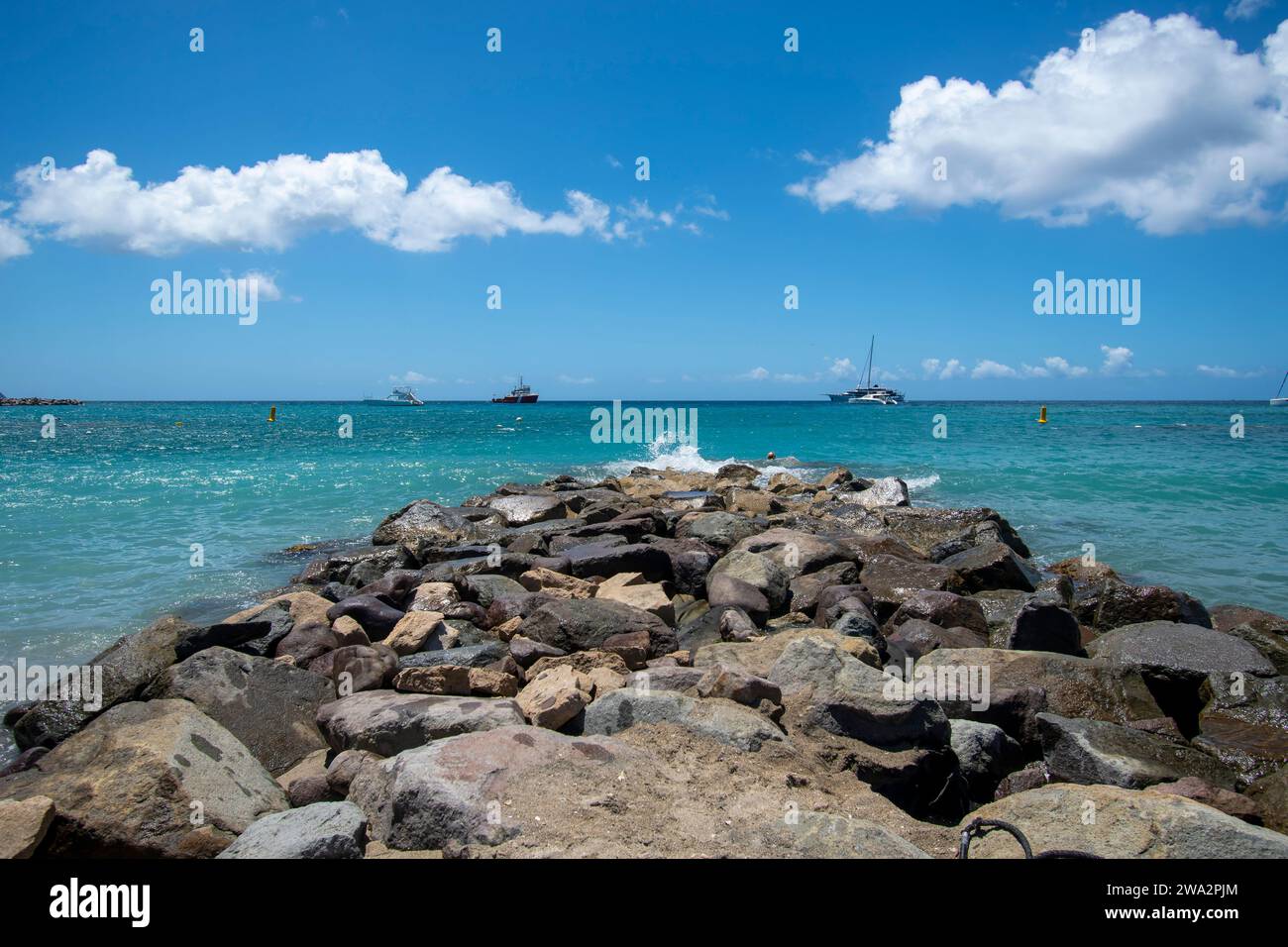 A groyne of rocks reaches out into the Caribbean sea from Frigate bay ...