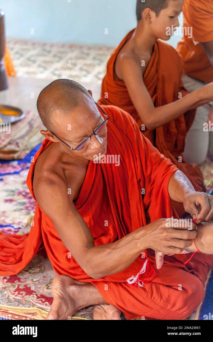 Buddhist monks performing a blessing ceremony and tying strings on the ...