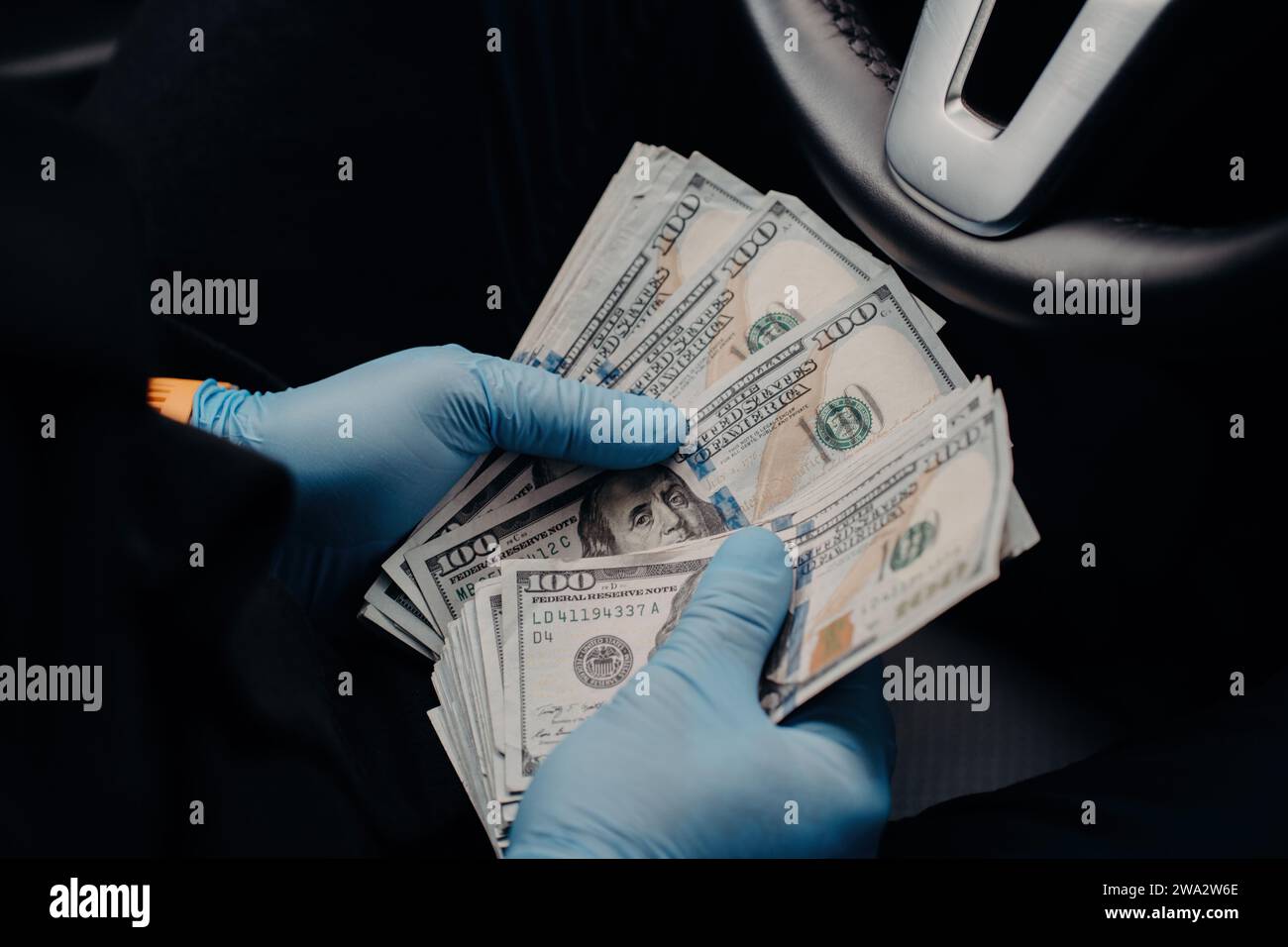 Gloved hands counting a stack of hundred-dollar bills, emphasizing hygiene and financial ...