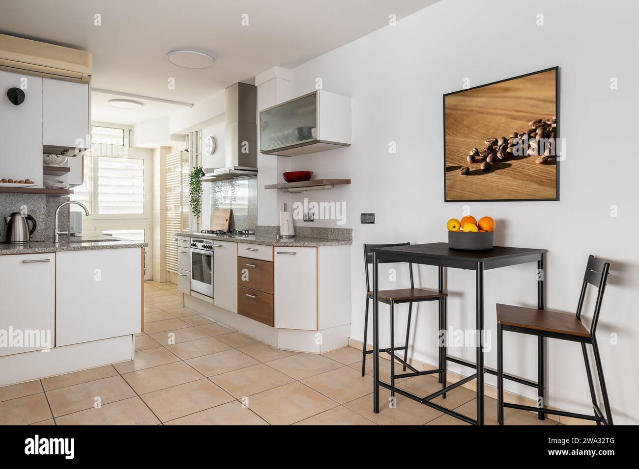 Kitchen area with units and high table to eat in apartment Stock Photo ...