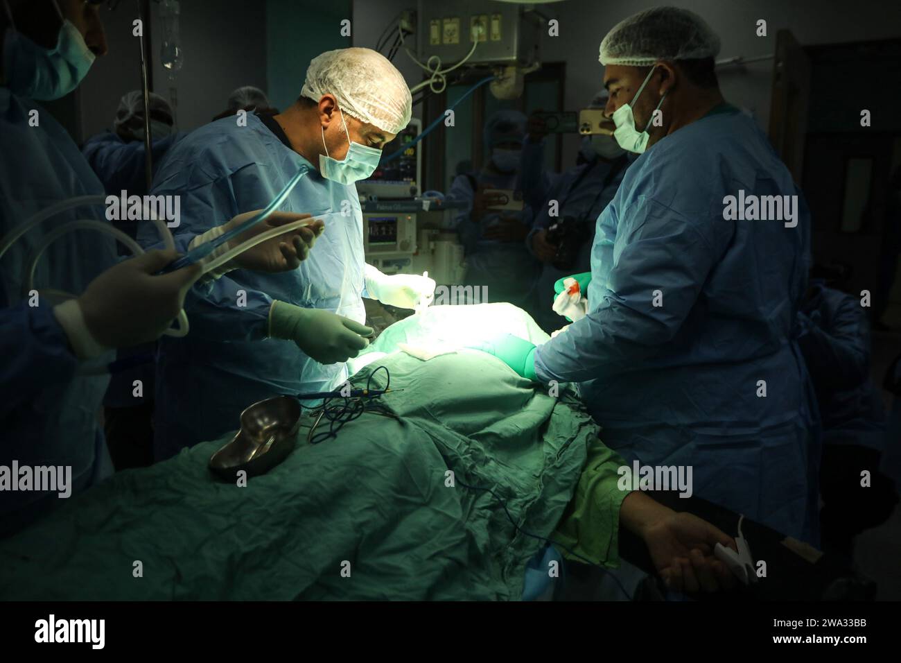 Khan Yunis, Gaza. 31st Dec, 2023. American surgeon Imad (C) operates on ...