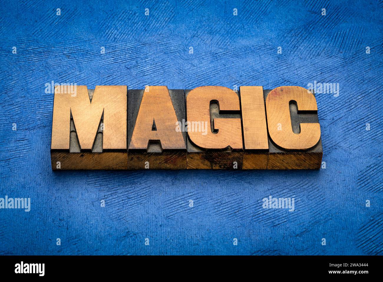 magic word abstract in vintage letterpress wood type against blue art ...