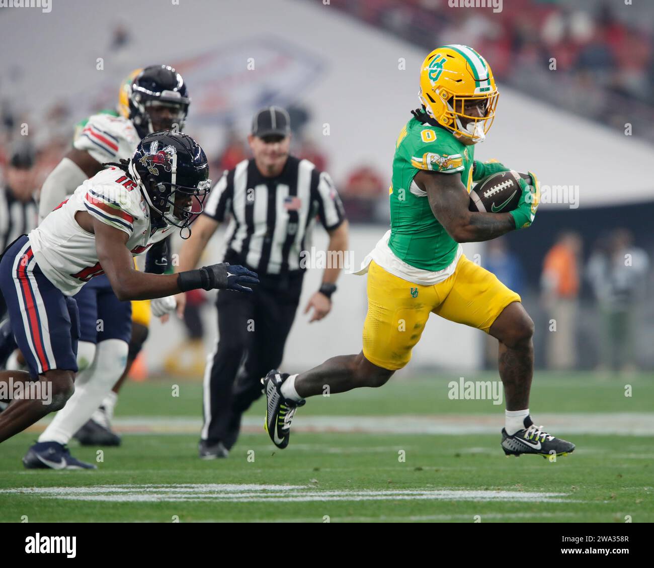 Glendale, Arizona, USA. 1st Jan, 2024. Bucky Irving (0) of the Oregon Ducks durning gets to the ...