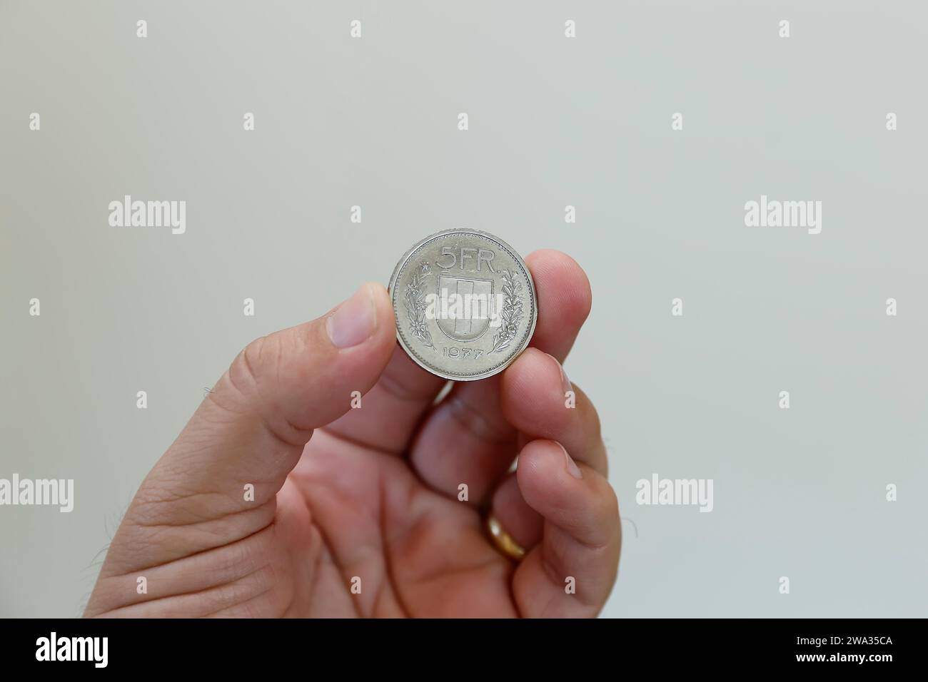 swiss five franc coin between fingers - swiss franc coin Stock Photo ...