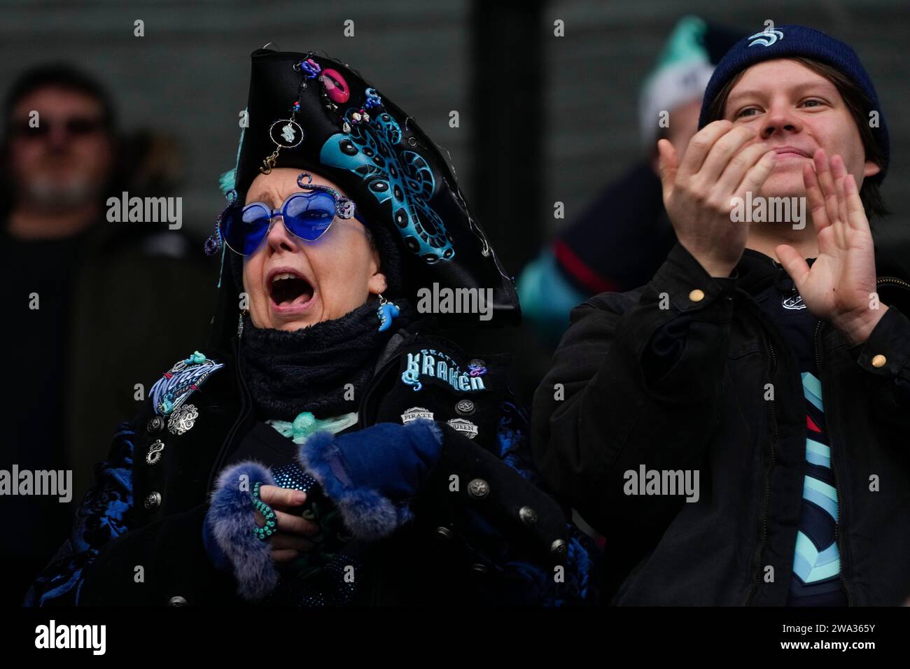 A fan wearing Seattle Kraken gear yells from the stands during warmups ...