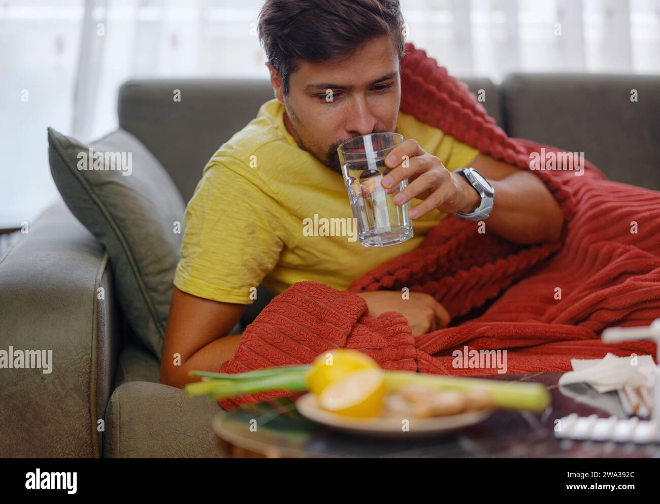 Young Caucasian man taking a pill with glass of water, ready to take ...