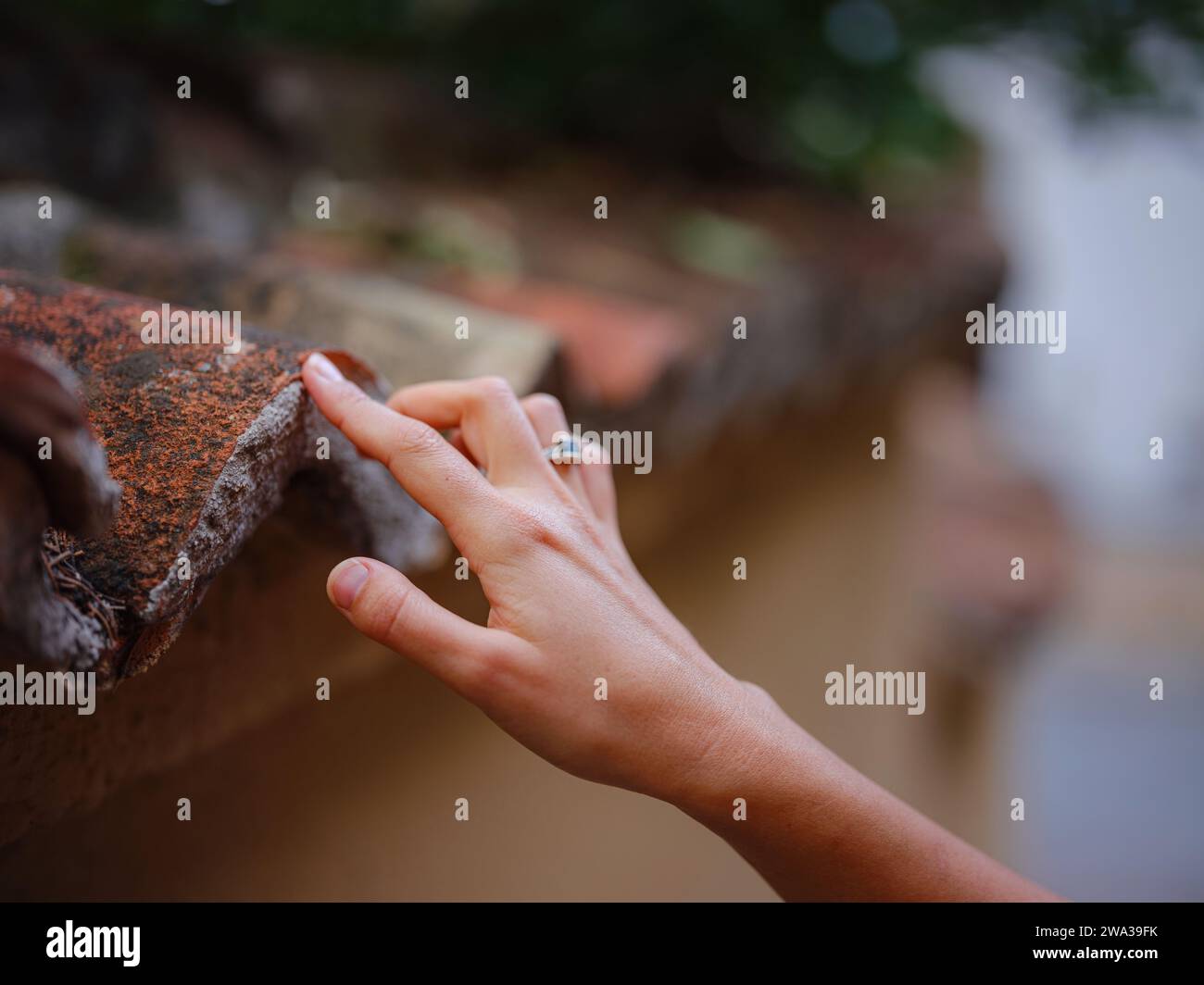 Female hand gently touches weathered tiles in old town of Kalechi ...