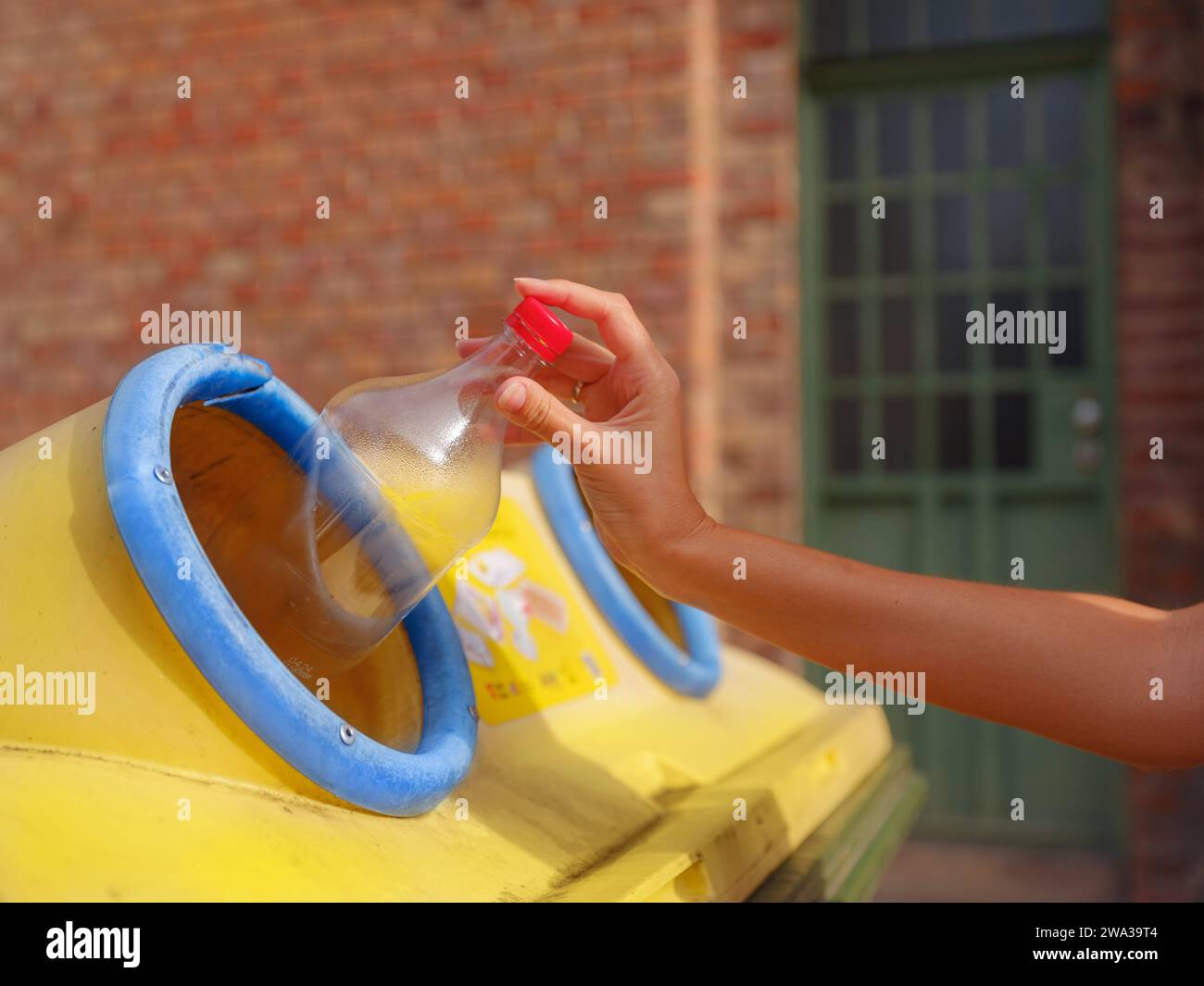 woman throwing plastic bottle Recycling bin stand on european street ...