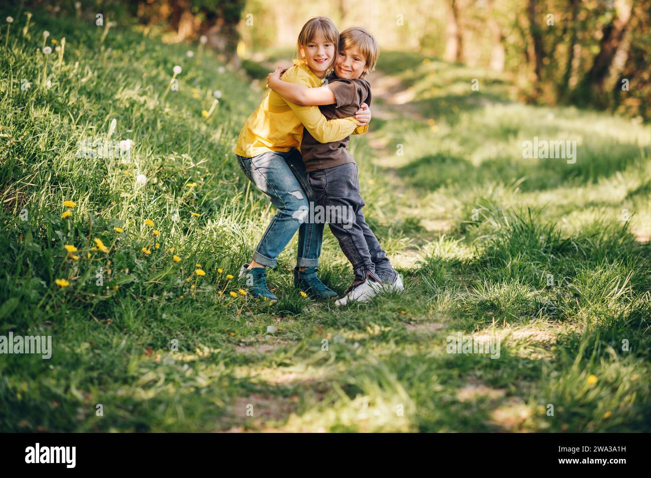 Two funny kids playing together in spring forest, little brother and ...