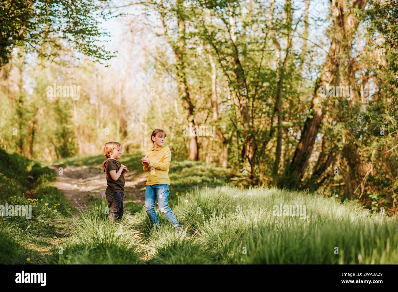 Two funny kids playing together in spring forest, little brother and ...