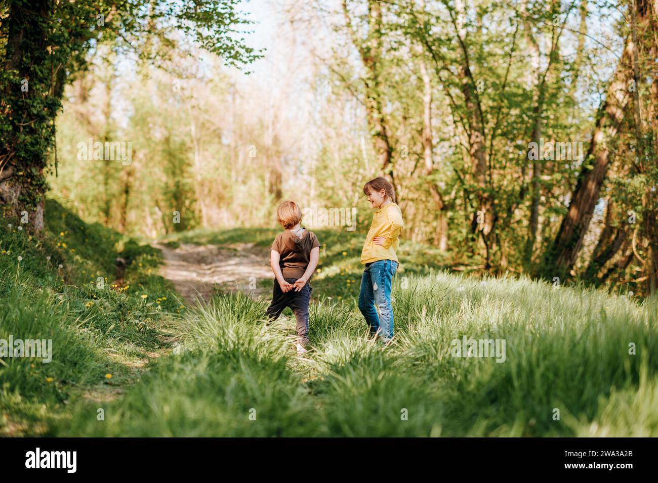 Two funny kids playing together in spring forest, little brother and ...