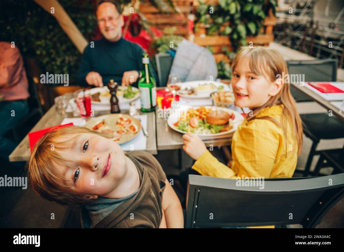 Happy family eating hamburger with french fries and pizza in outdoor ...