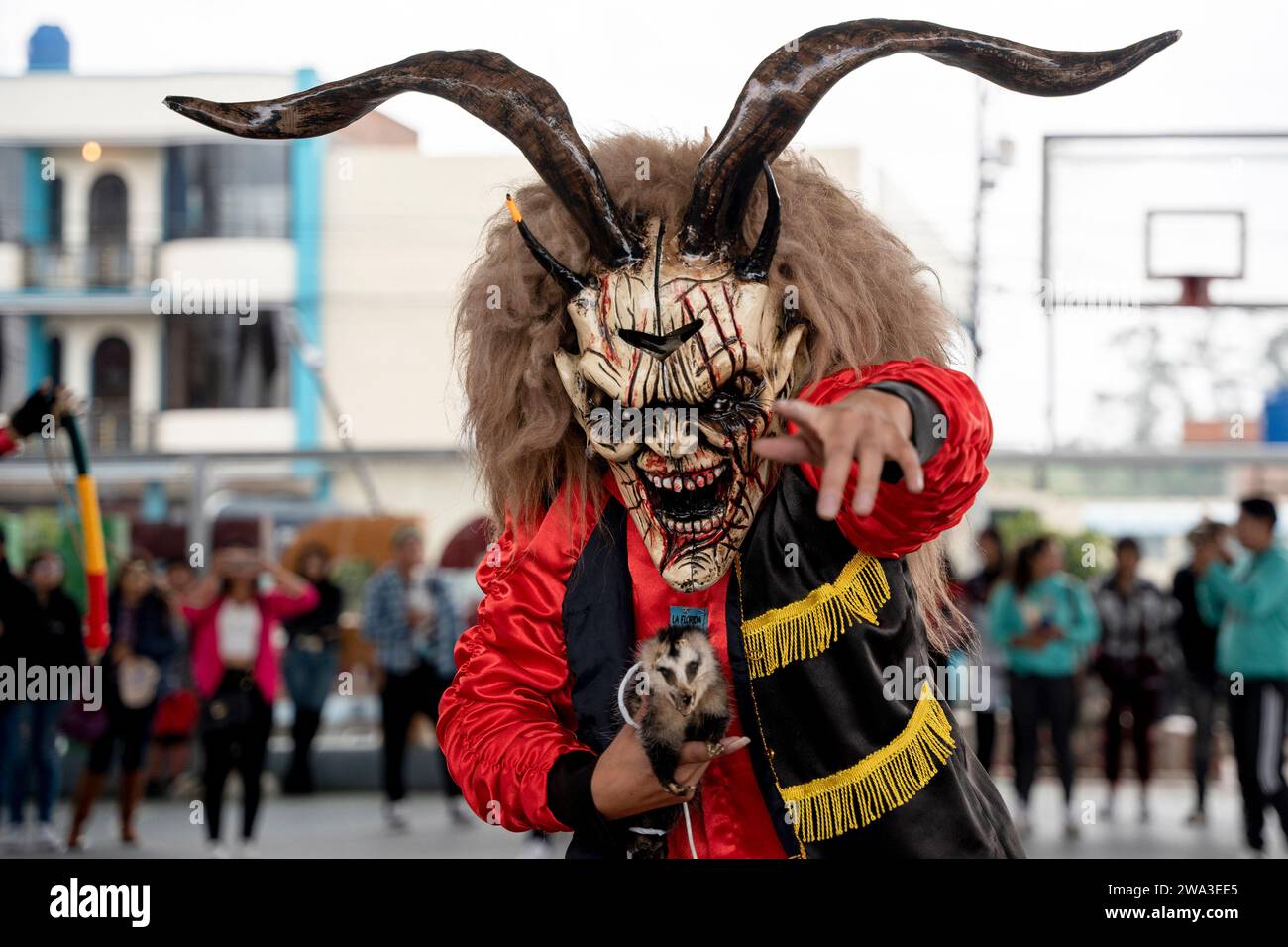 Wearing a devil mask, a reveler dances through the streets during the ...