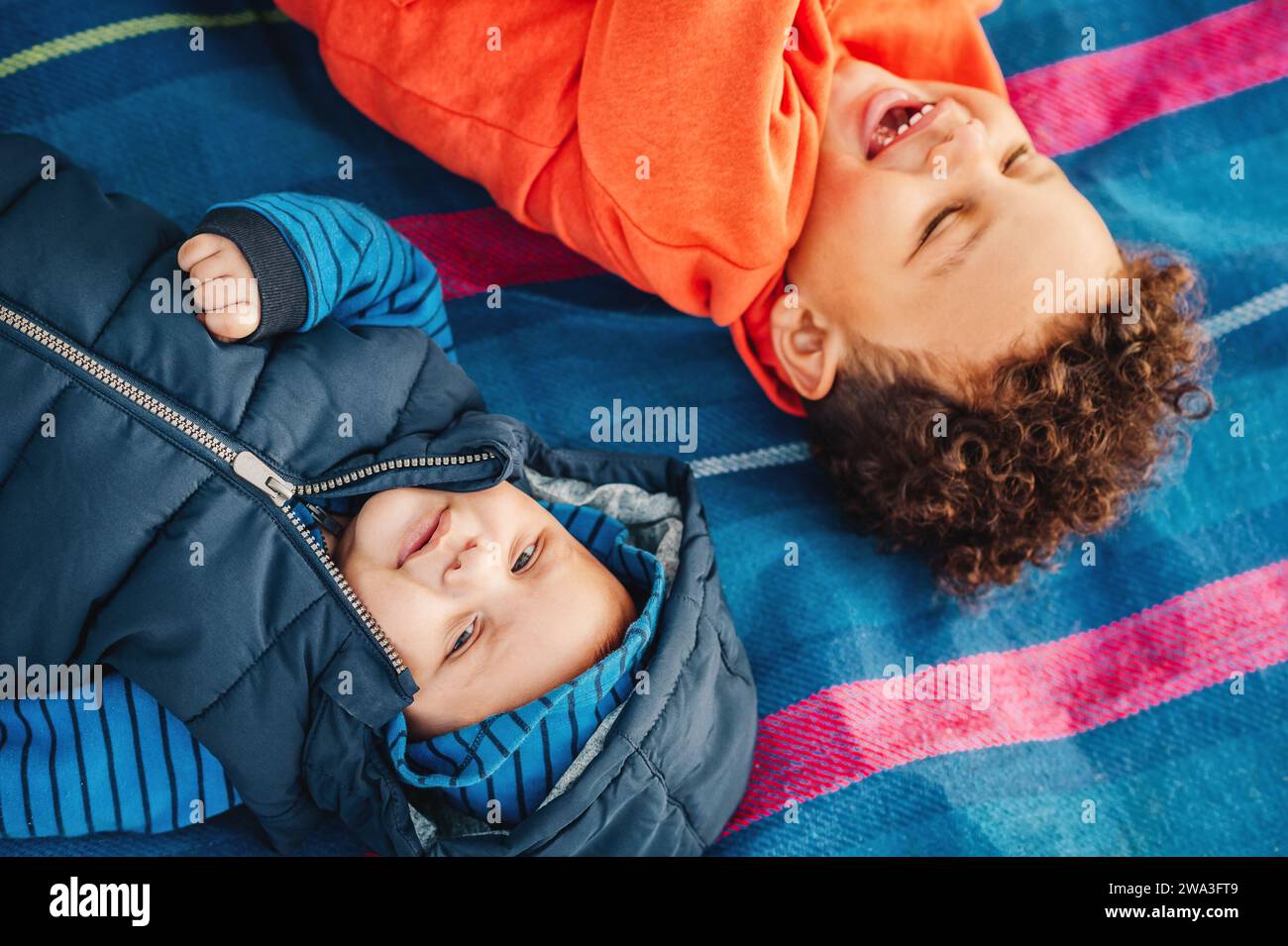 Portrait of two funny brothers playing utside, baby and toddler boys ...