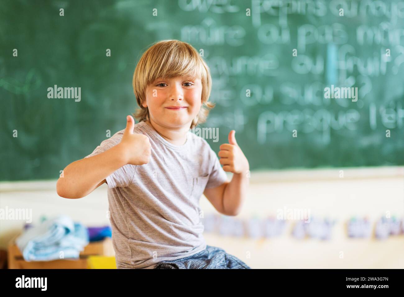 Happy child working in classroom, big thumbs up, education, back to ...
