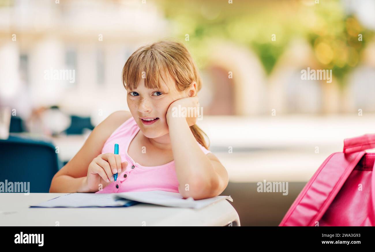 Cute kid girl doing school homework outside, home schooling, education ...
