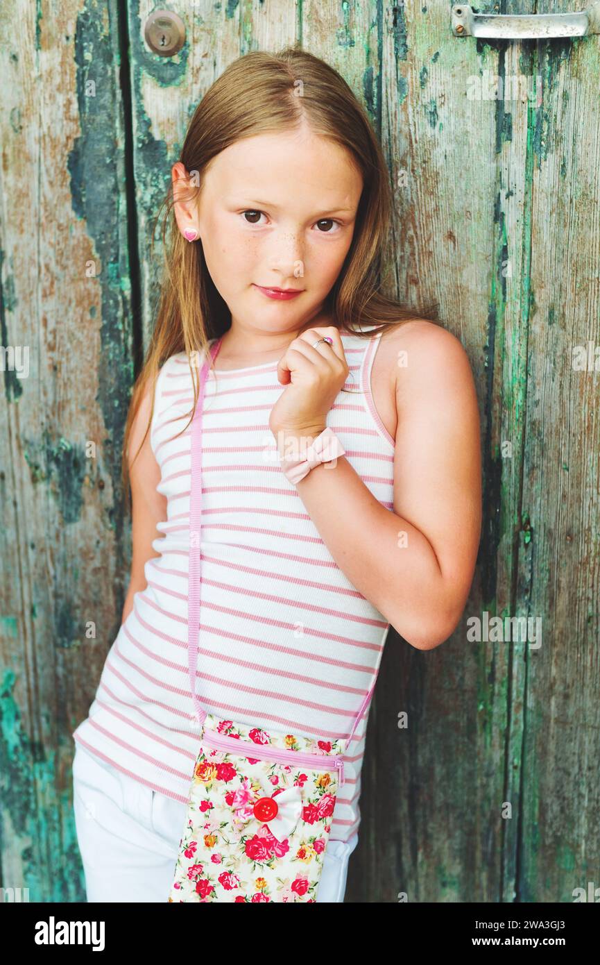 Portrait of a cute little 7-8 year old girl wearing many accessories ...