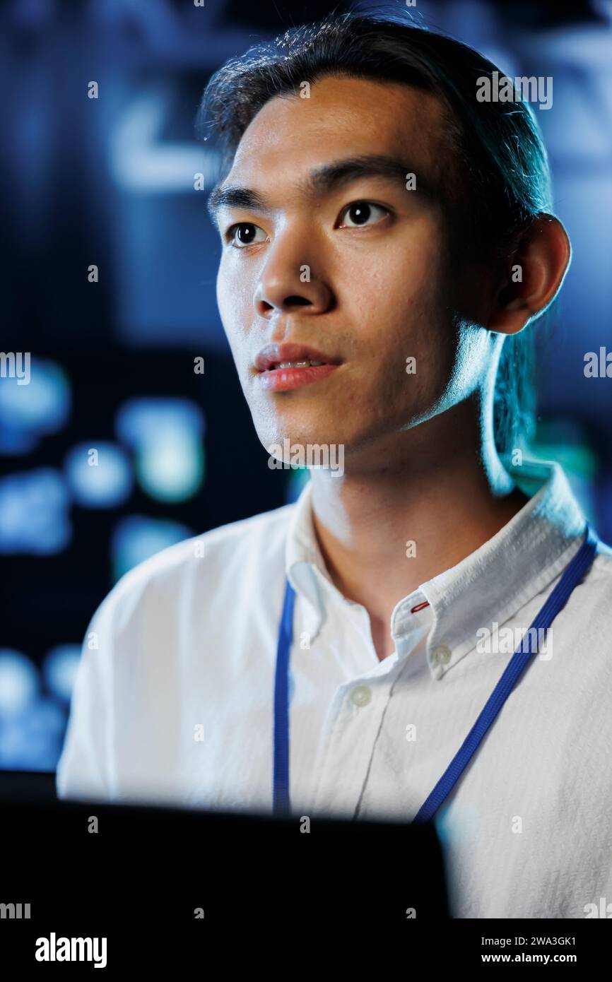 Portrait of technician between server hub clusters providing processing resources for businesses ...