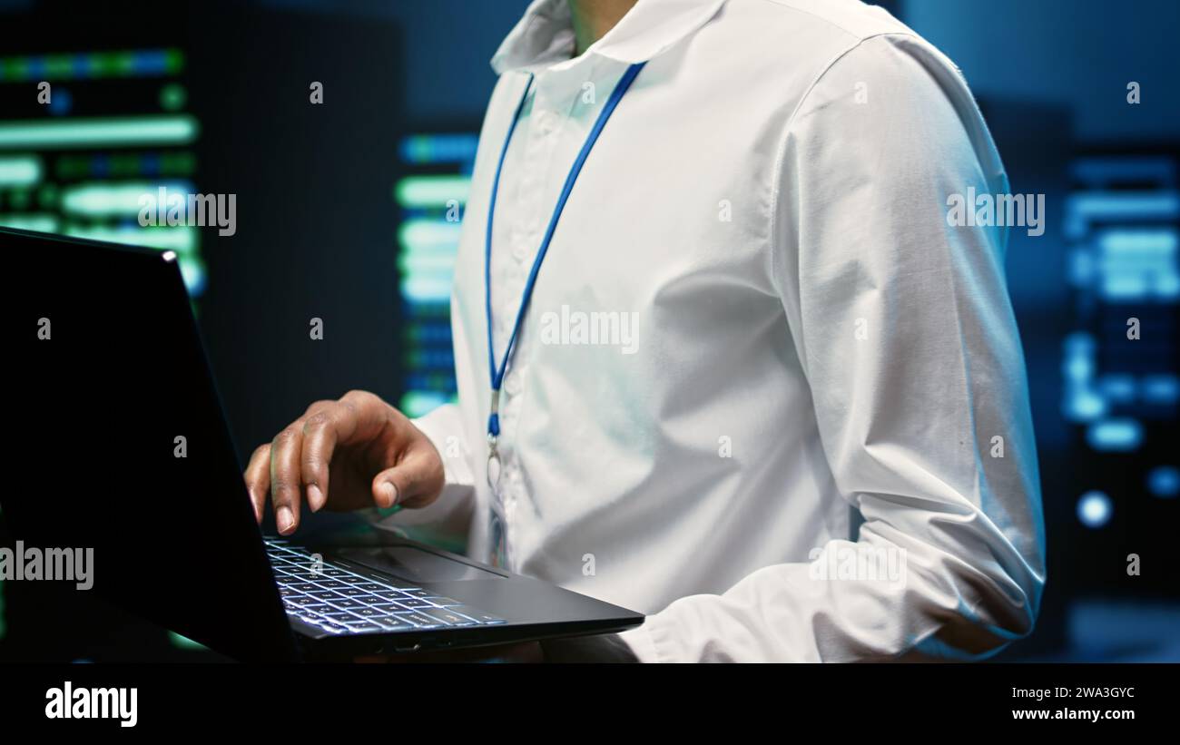 Precise technician in high tech facility repairing network issues ...