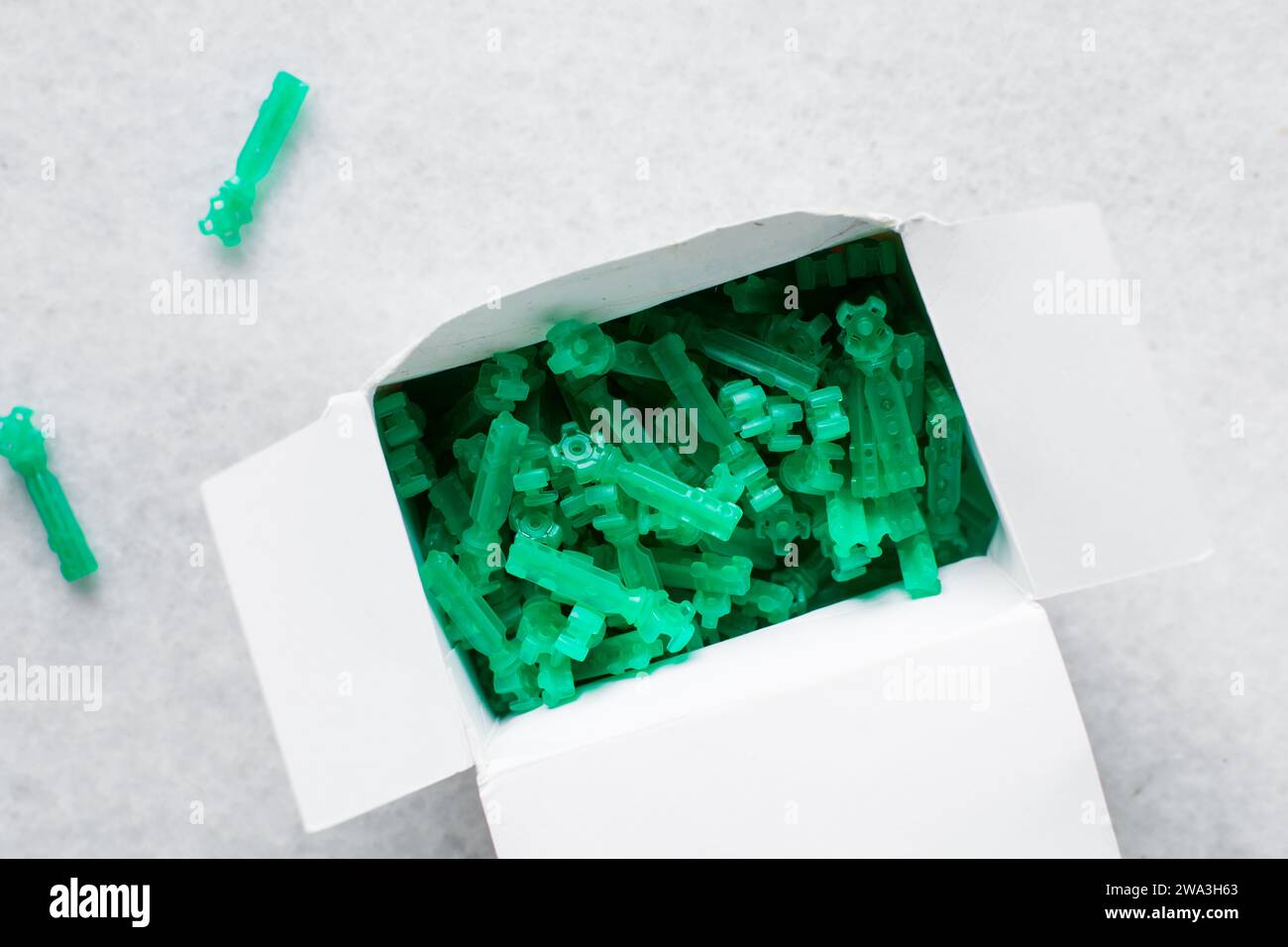 Blood lancets on a marble countertop, top view of green lancets on a ...