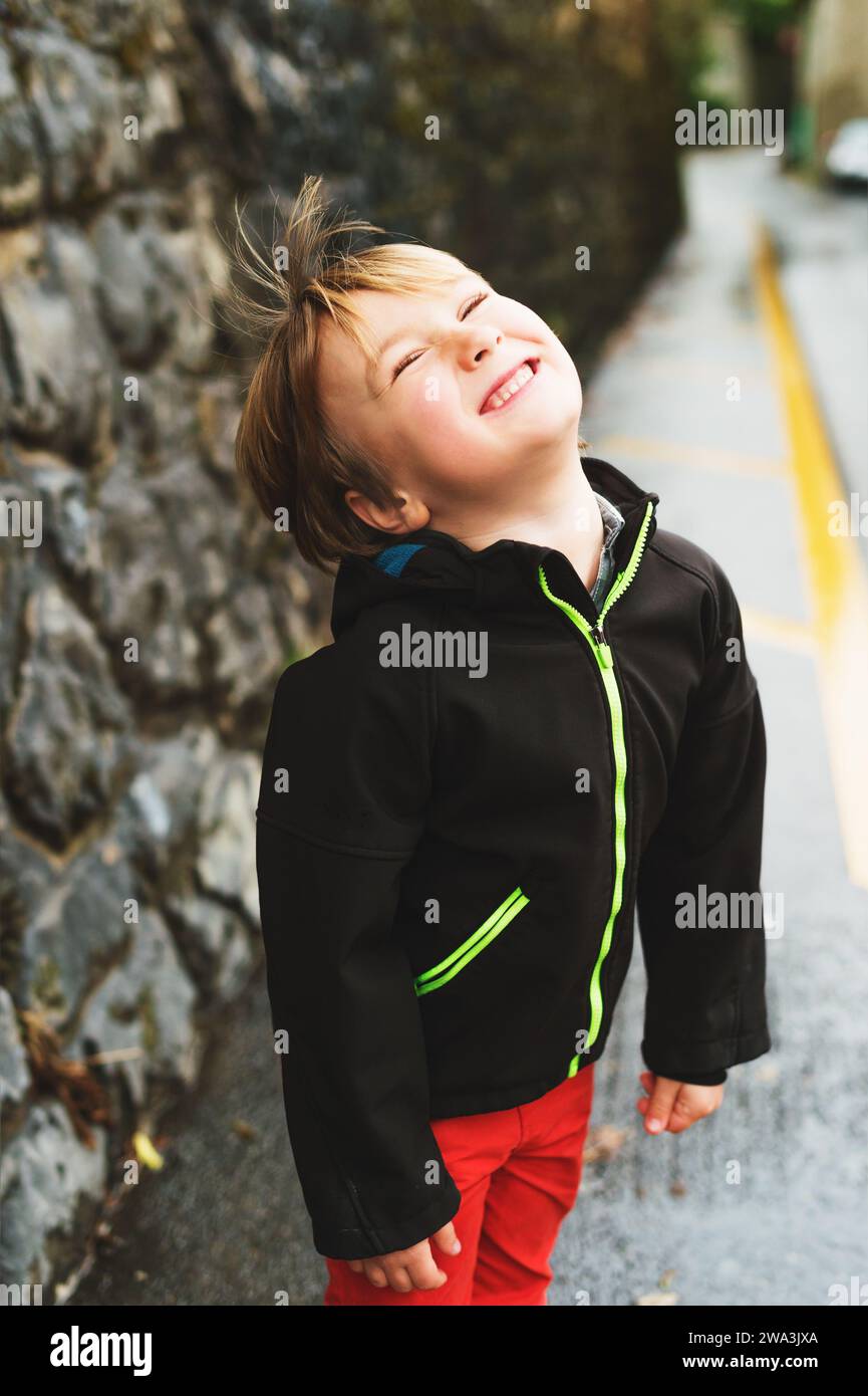 Little 5-6 year old boy playing outdoors in early spring, walking next ...
