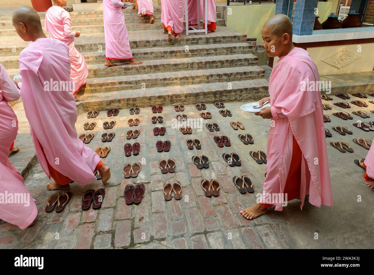 Buddhist nuns removing sandals before entering the dining hall at the ...